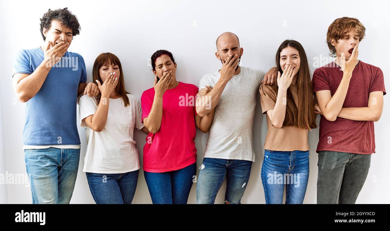 Group of young friends standing together over isolated background bored ...