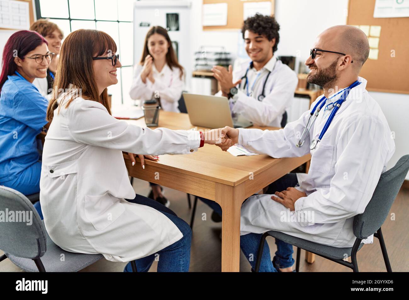 Group of doctor smiling and clapping to partners handshake in a medical ...