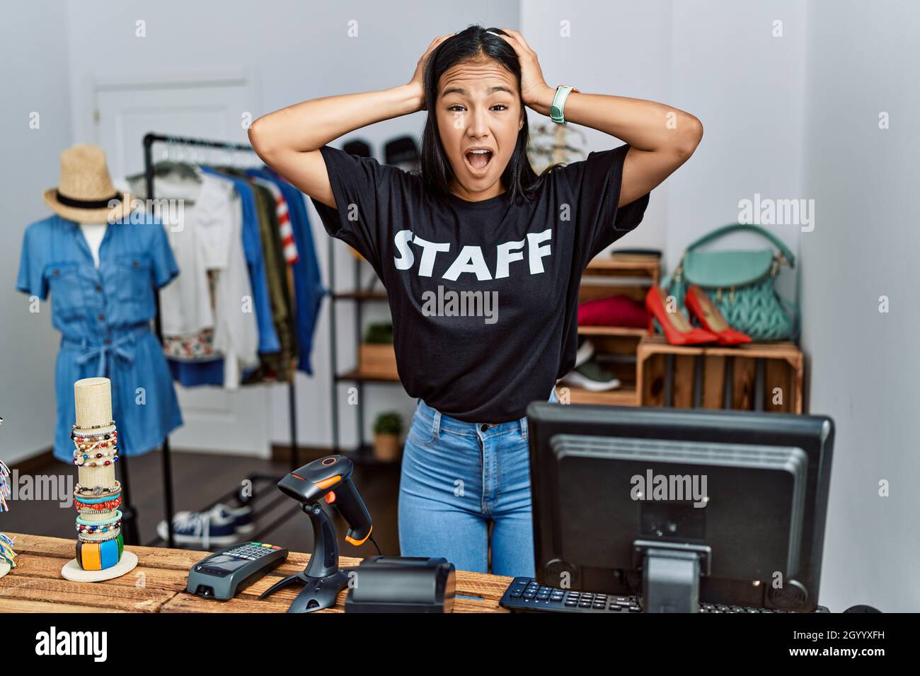 Young hispanic woman working as staff at retail boutique crazy and ...