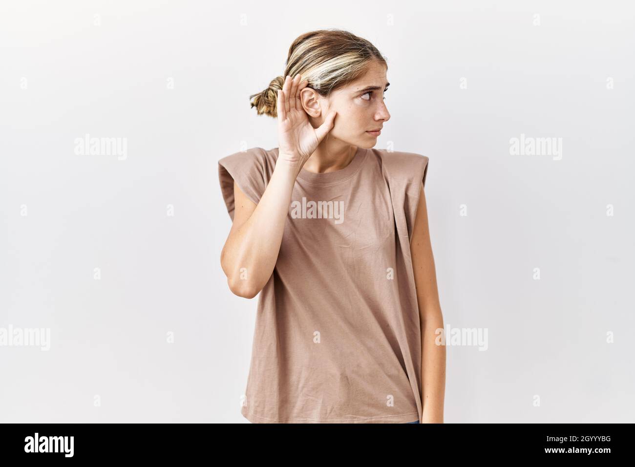 Young blonde woman standing over isolated background smiling with hand ...