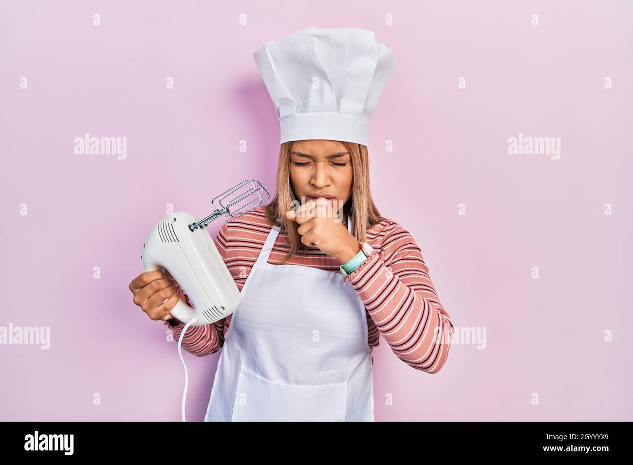 Beautiful hispanic woman holding pastry blender electric mixer feeling ...
