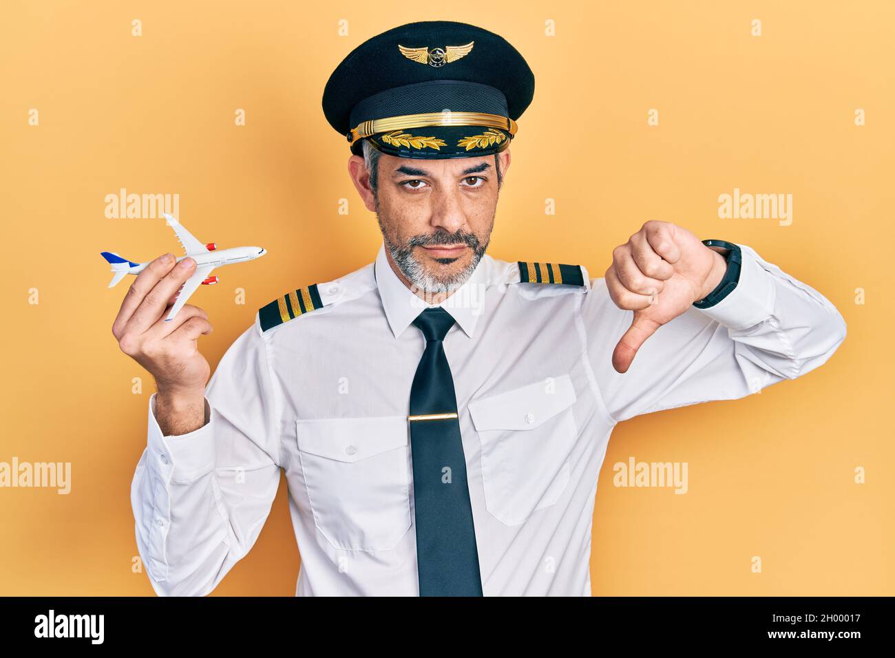 Handsome middle age man with grey hair wearing airplane pilot uniform ...