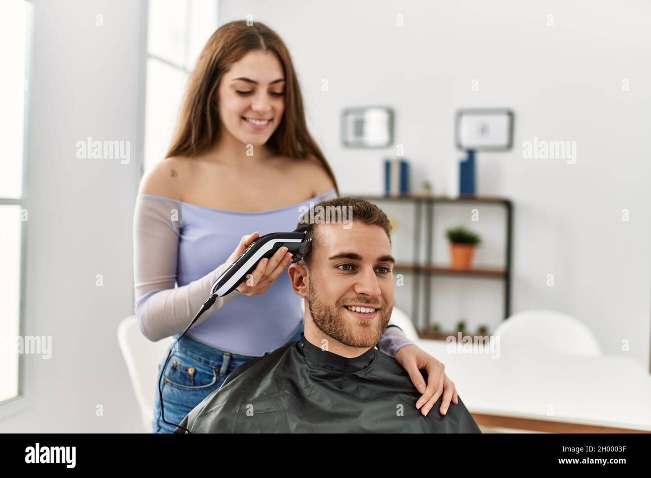 Young woman cutting hair her boyfriend at home Stock Photo - Alamy