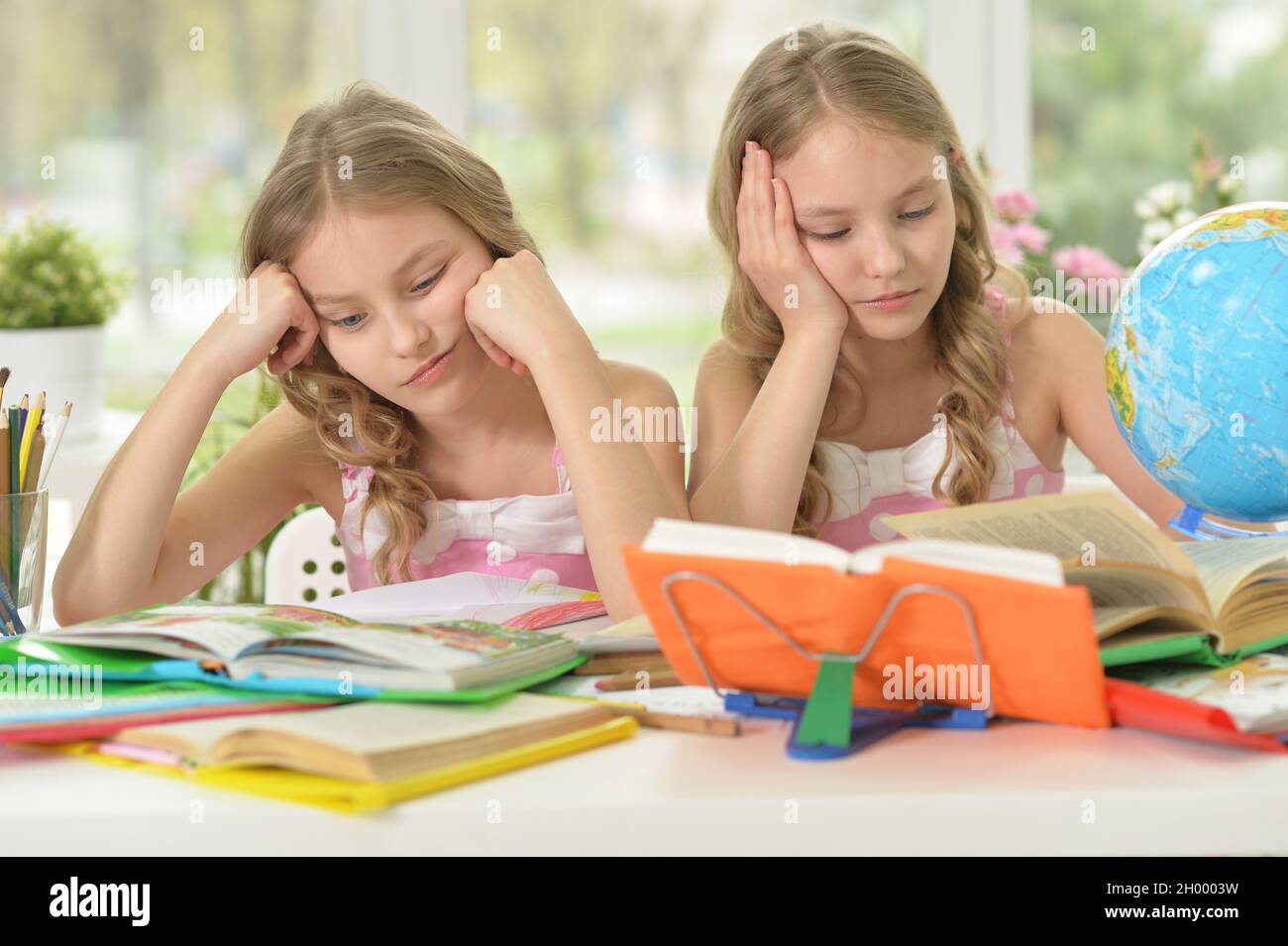Two girls are sitting and reading books Stock Photo - Alamy