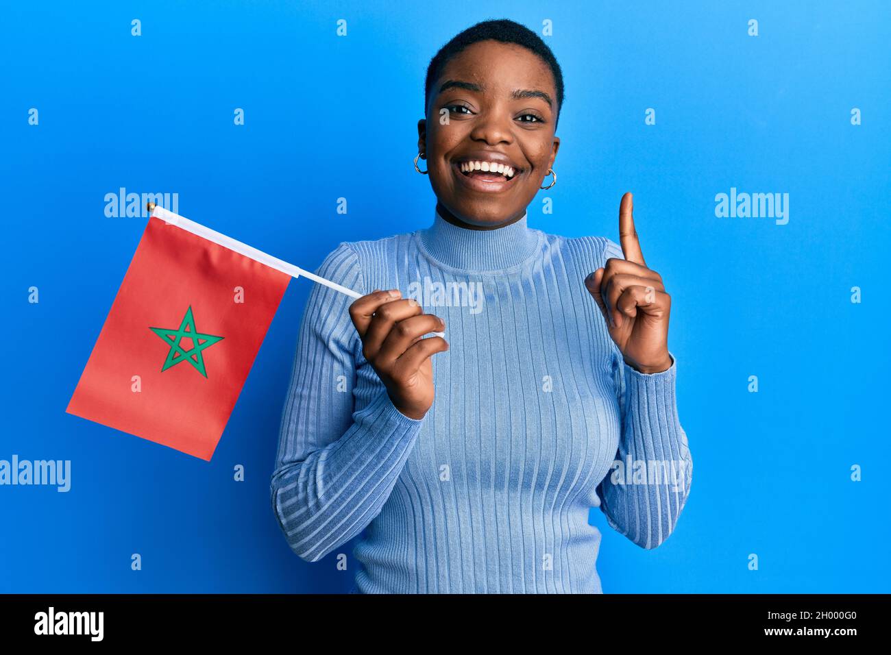 Young african american woman holding morocco flag smiling with an idea ...