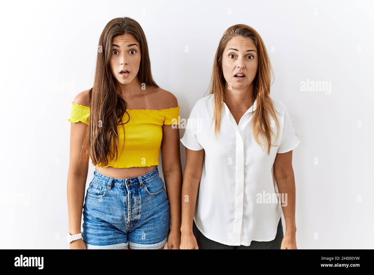 Mother and daughter together standing together over isolated background ...