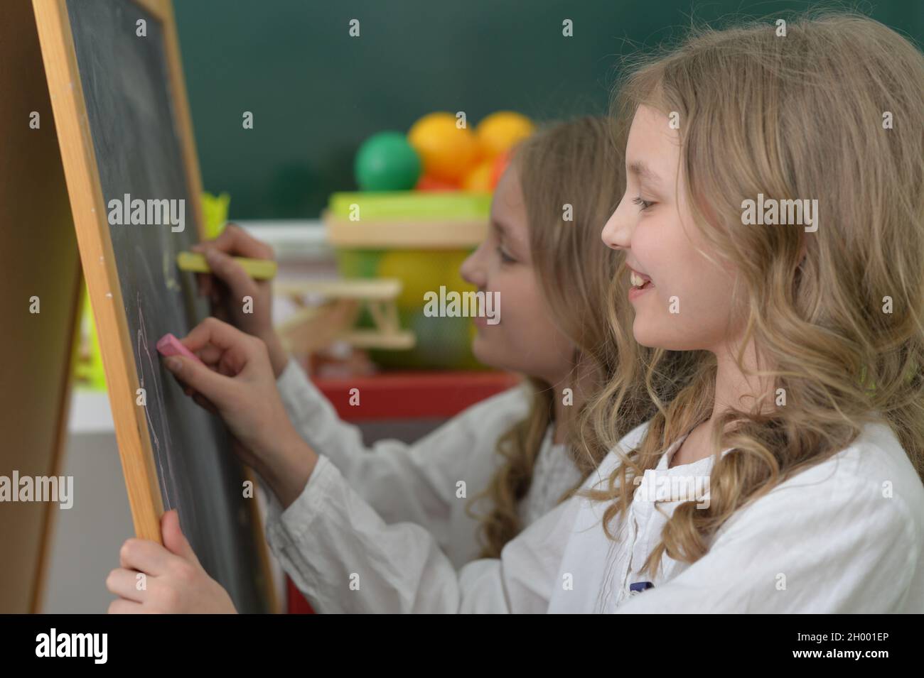 Portrait of beautiful girls doing homework on blackboard Stock Photo ...