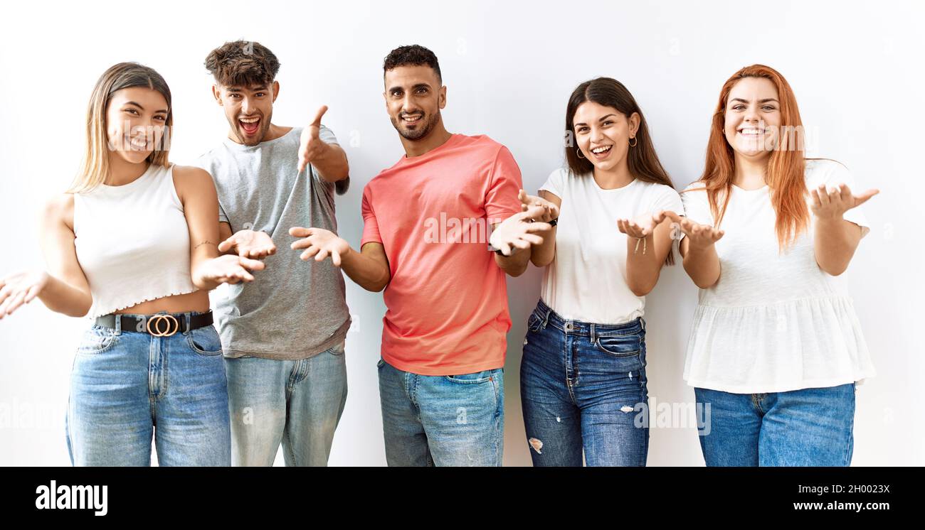 Group of young friends standing together over isolated background ...