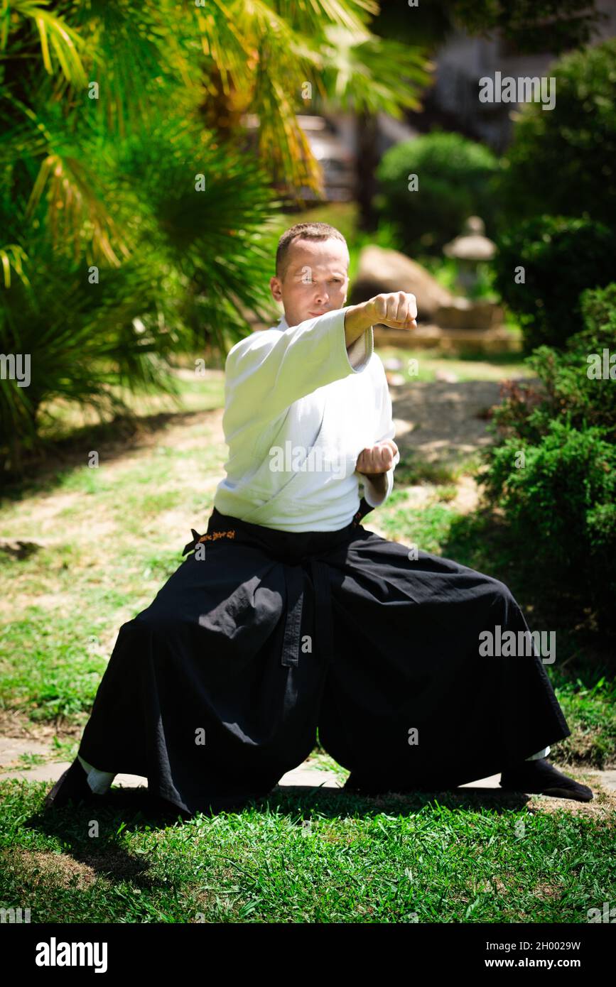 Young serious man aikido master in traditional costume Stock Photo - Alamy