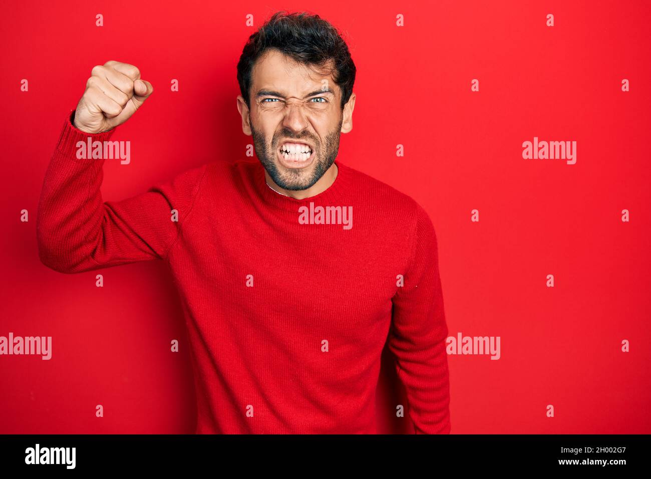 Handsome man with beard wearing casual red sweater angry and mad ...