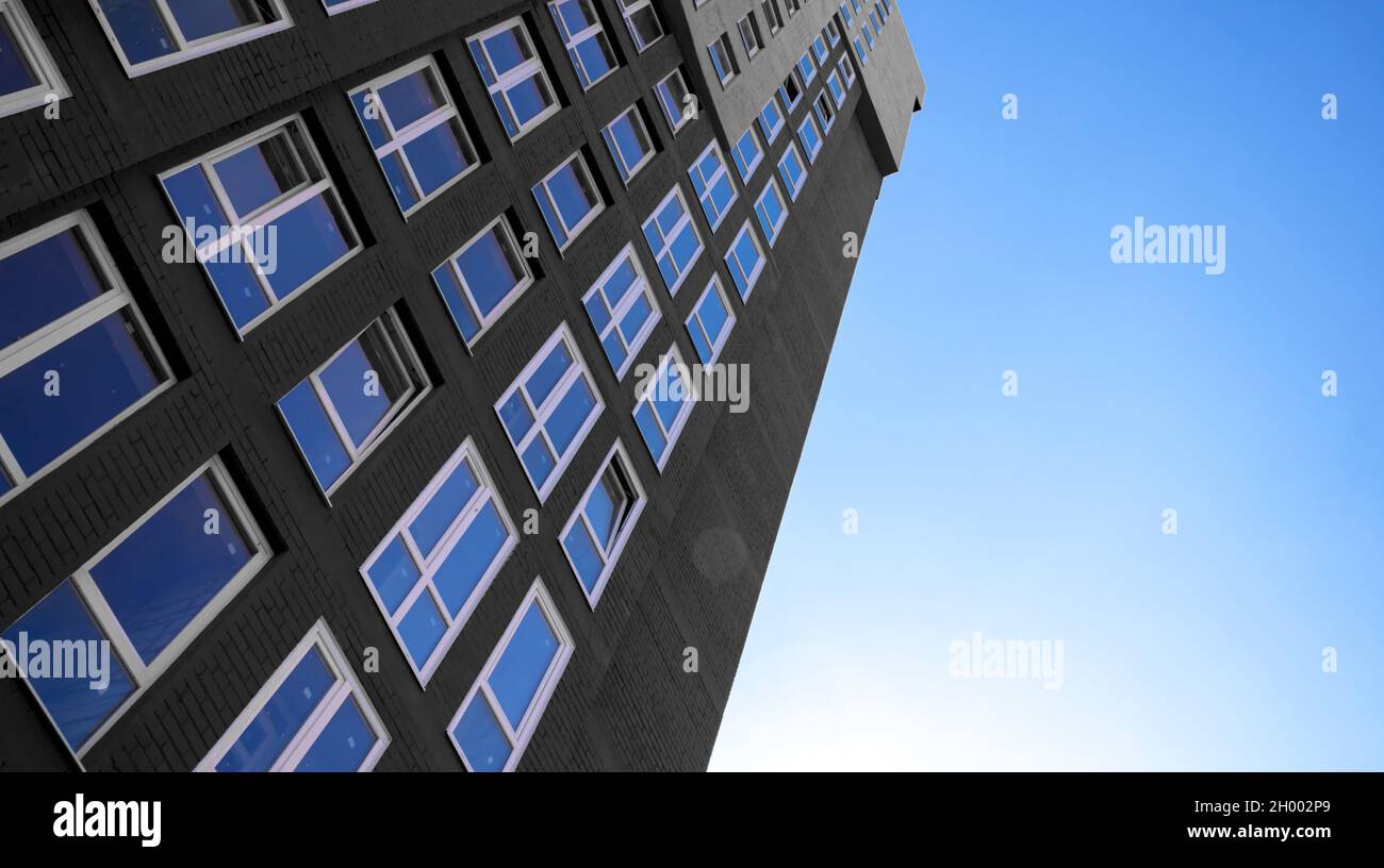 Black and white residential high-rise building with many glass windows ...
