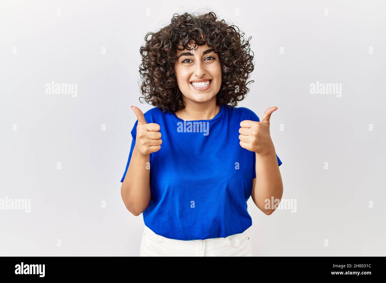 Young middle eastern woman standing over isolated background success ...