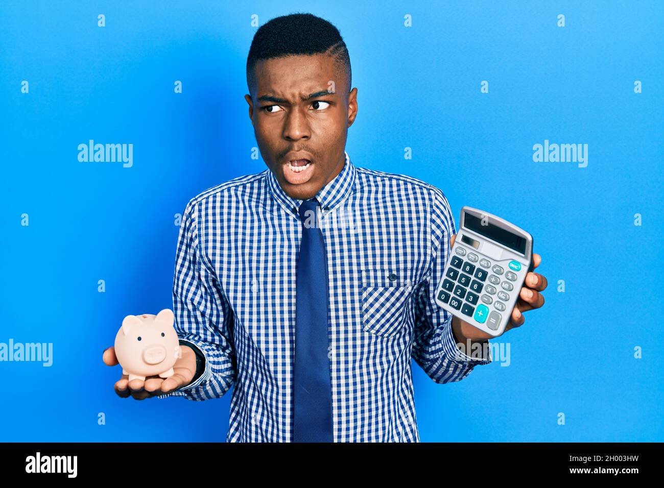 Young african american man calculating money savings angry and mad ...