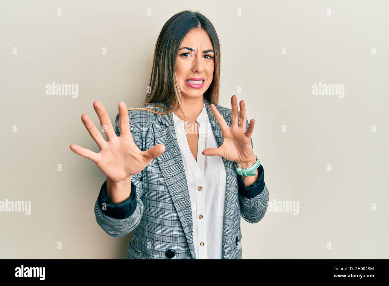 Young hispanic woman wearing business clothes disgusted expression ...