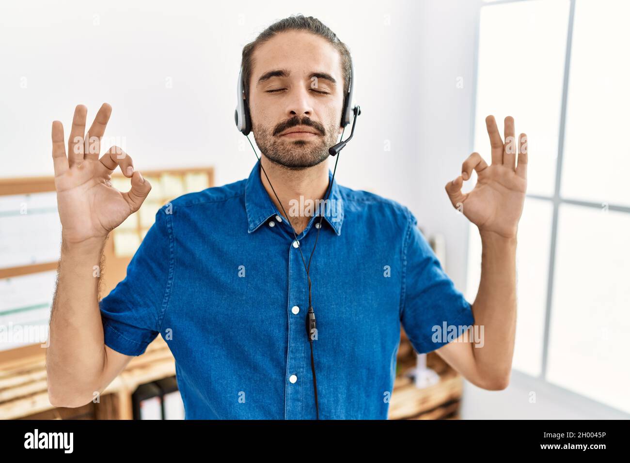 Young hispanic man with beard wearing call center agent headset at the ...