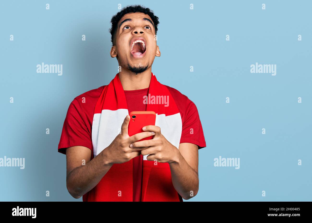 Young african american man football hooligan cheering game holding ...