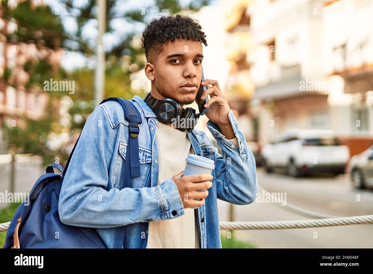 Hispanic young man speaking on the phone at the street Stock Photo - Alamy