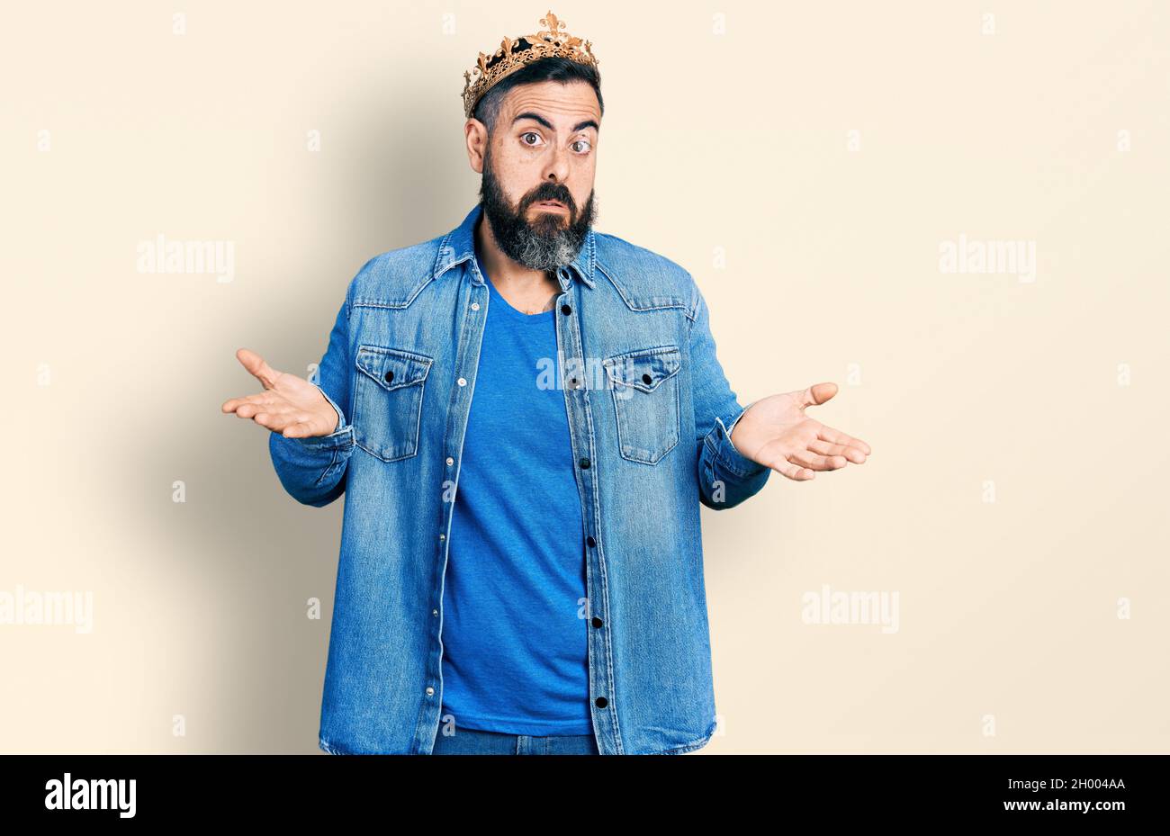 Hispanic man with beard wearing king crown clueless and confused ...
