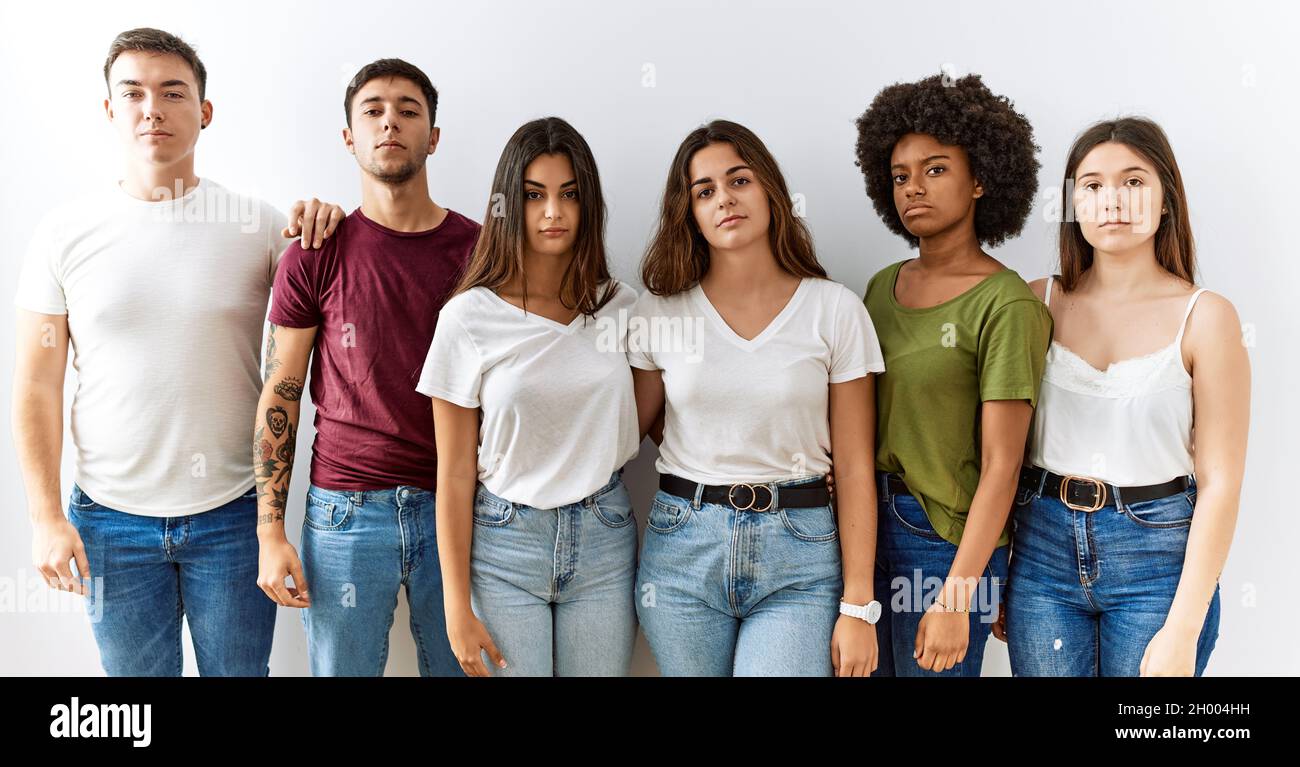 Group of young friends standing together over isolated background ...