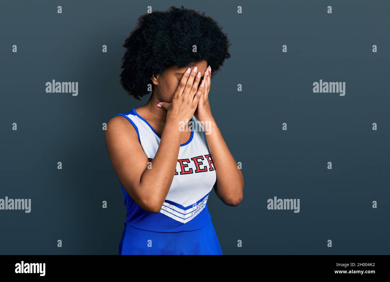 Young african american woman wearing cheerleader uniform with sad ...