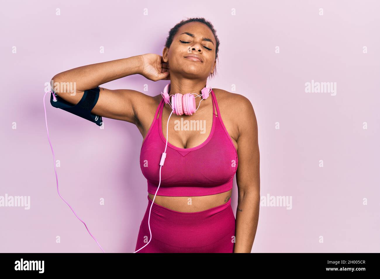 Young african american girl wearing gym clothes and using headphones ...