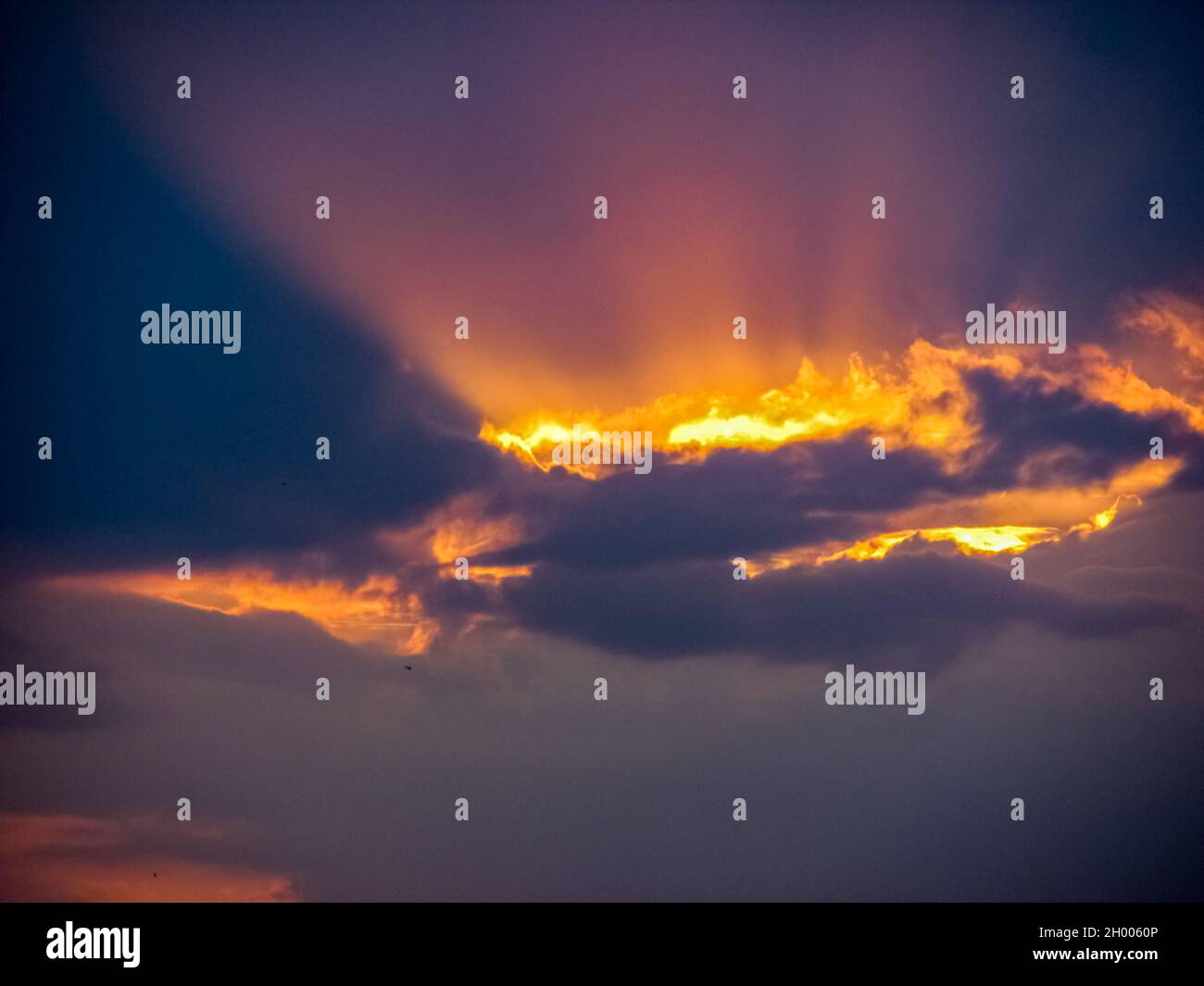 sun covered by cloud look like burning arrow in the sky Stock Photo - Alamy