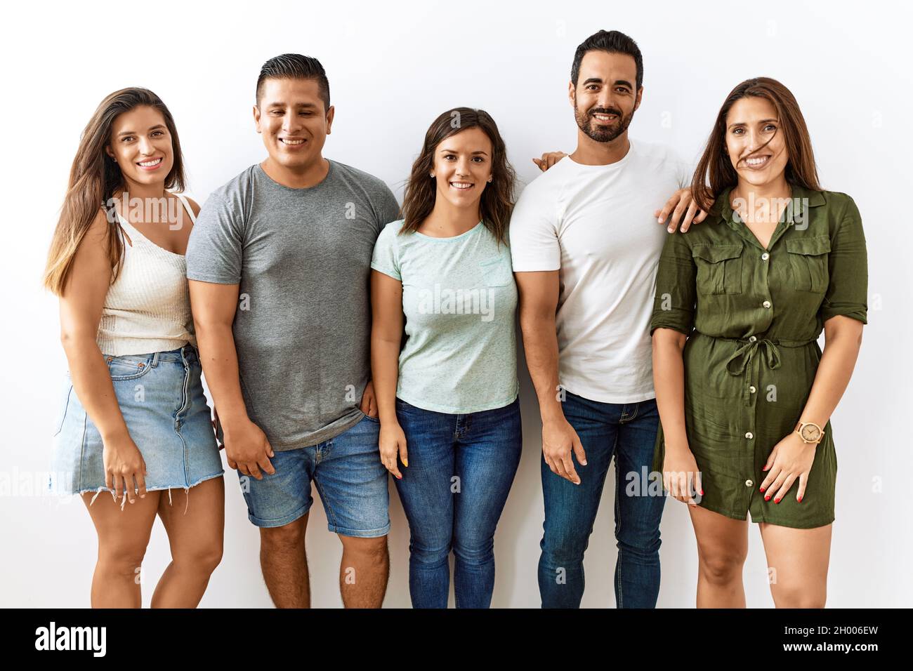 Group of young hispanic friends standing together over isolated ...