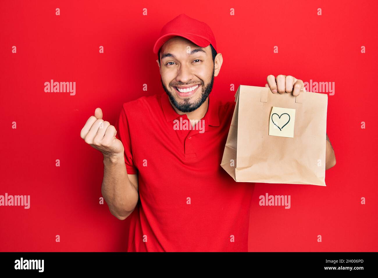 Hispanic man with beard holding take away paper bag with heart reminder ...