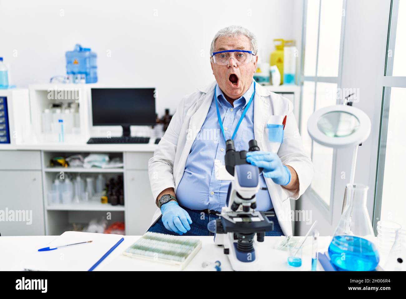 Senior caucasian man working at scientist laboratory in shock face ...