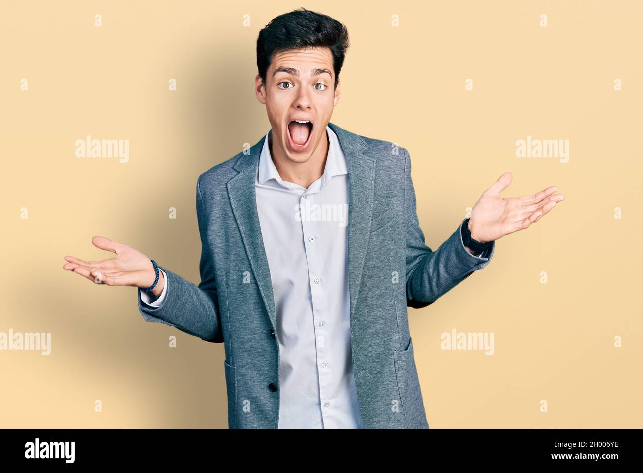 Young hispanic man wearing business clothes celebrating crazy and ...