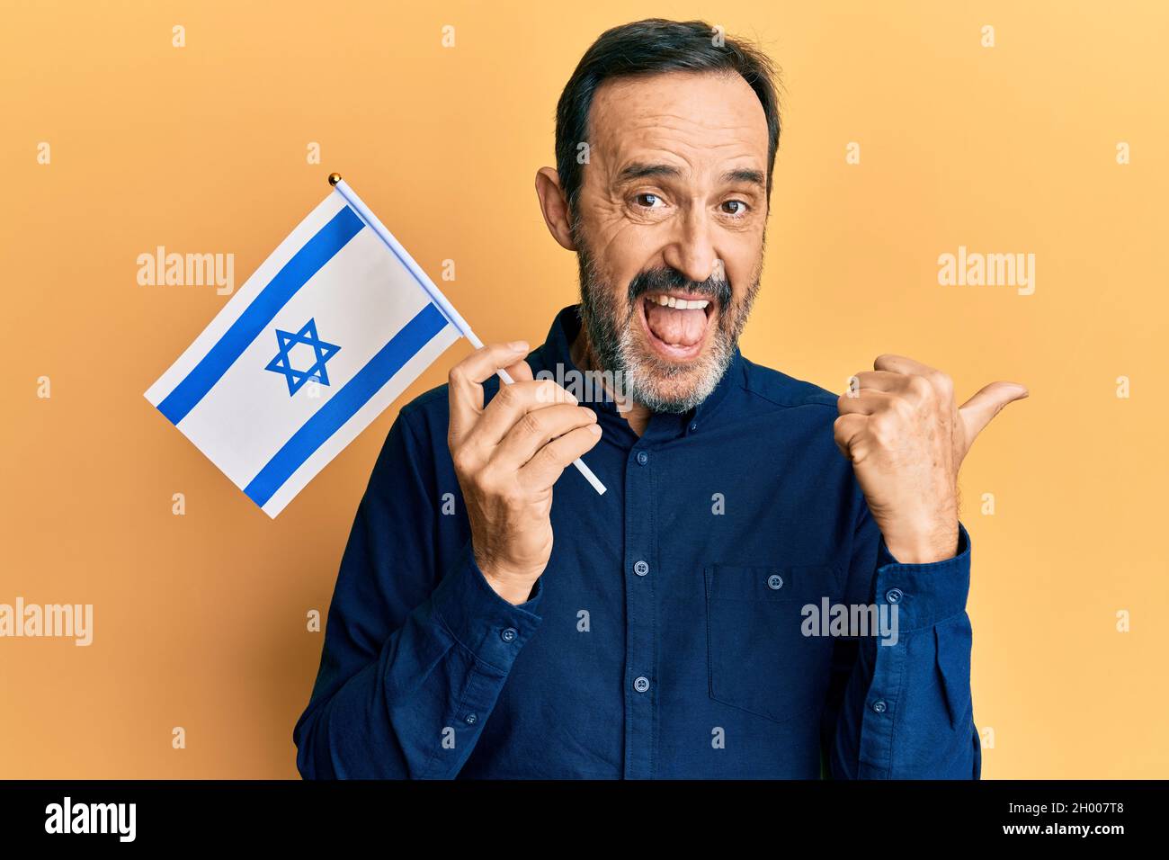 Middle age hispanic man holding israel flag pointing thumb up to the ...