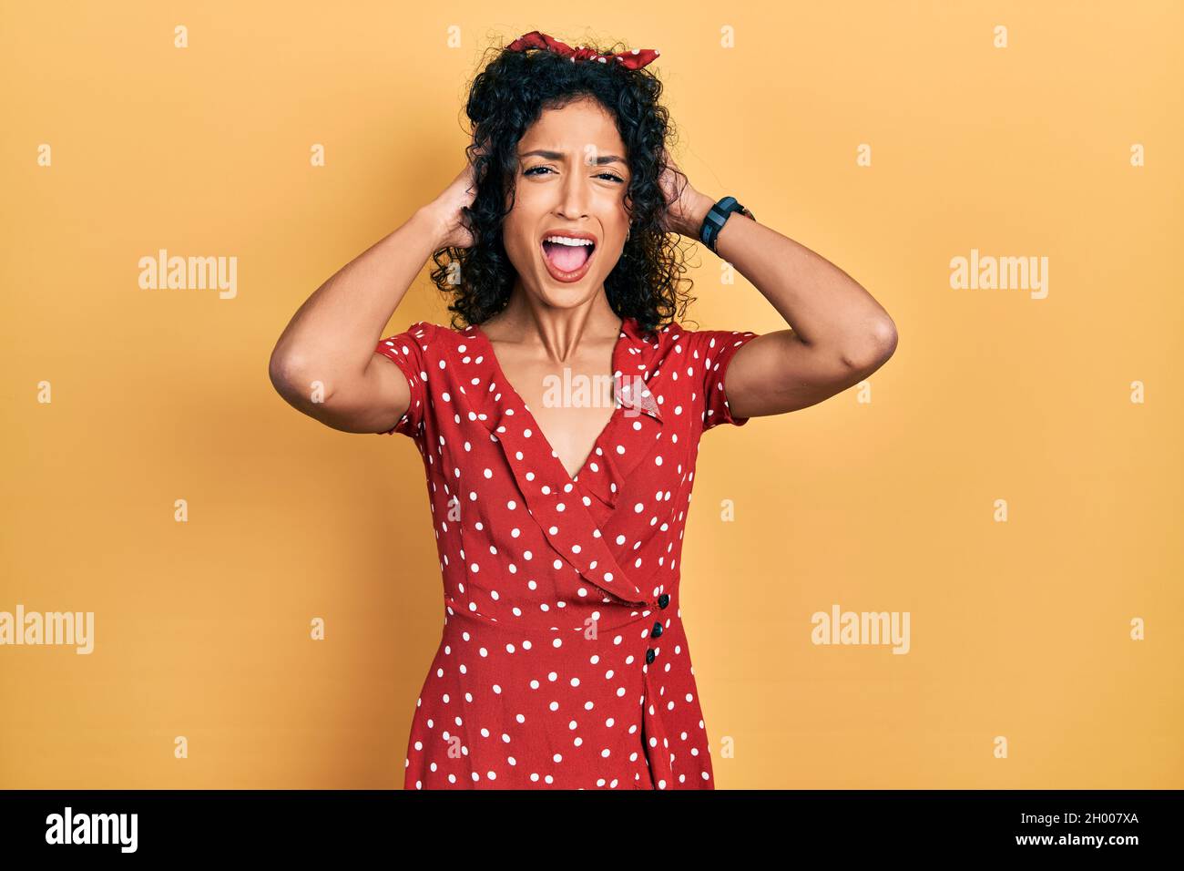 Young latin girl wearing summer dress crazy and scared with hands on ...