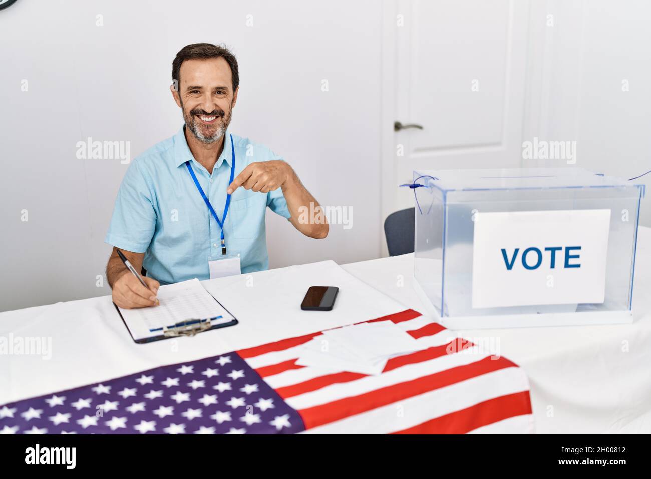 Middle age man with beard at political election sitting by ballot ...