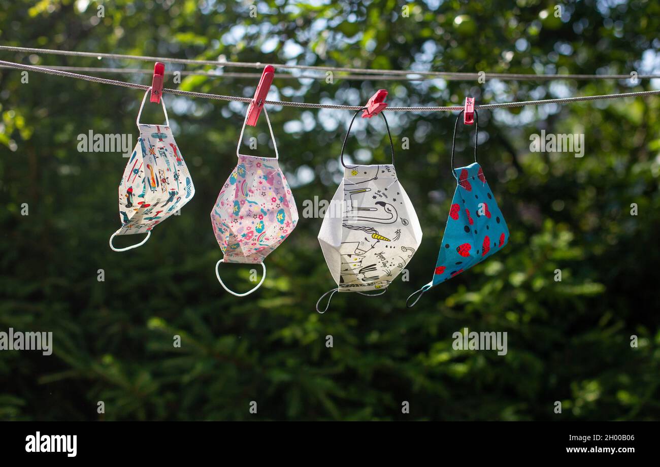 Close up of safety facial masks drying on hanger with clothespins ...