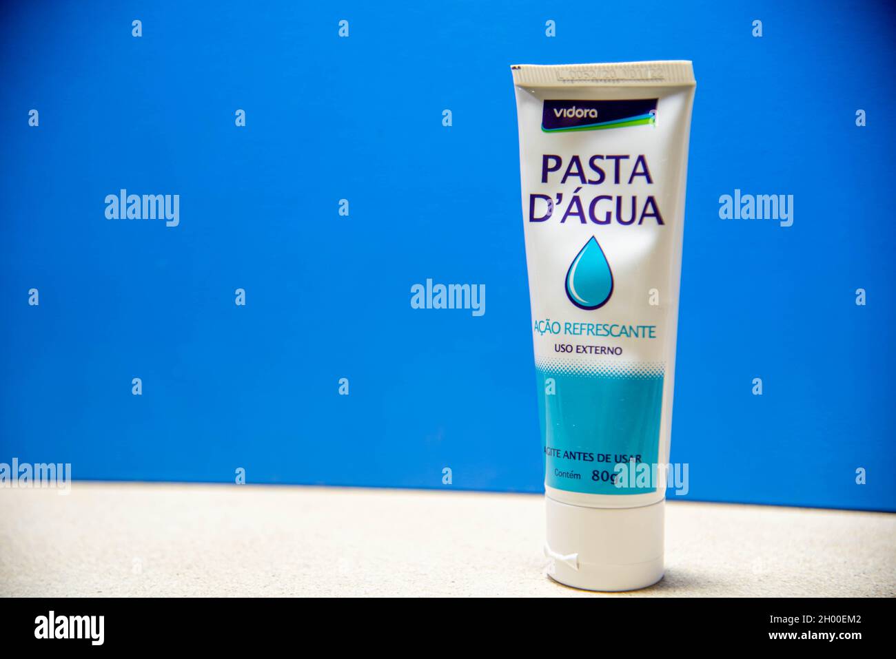 Jar of water paste on blue background. Burn relief medication ...