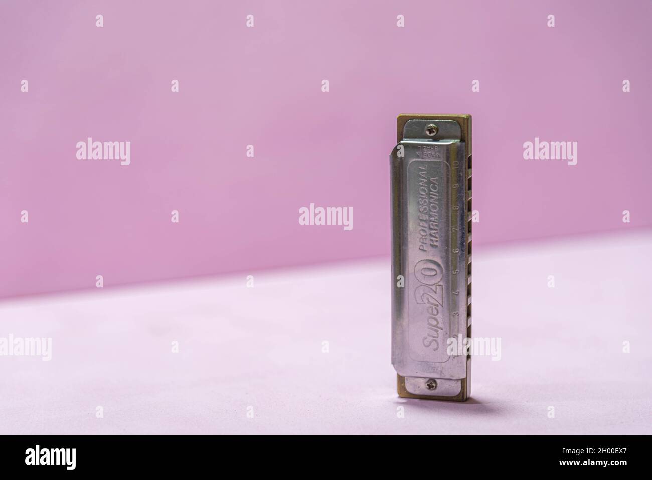 Harmonica. Musical instrument. Pink background. Wind instrument. Jazz ...