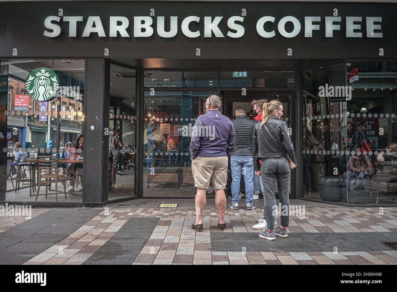 Customers queue for entry at Starbucks Coffee Shop on Castle Lane in ...