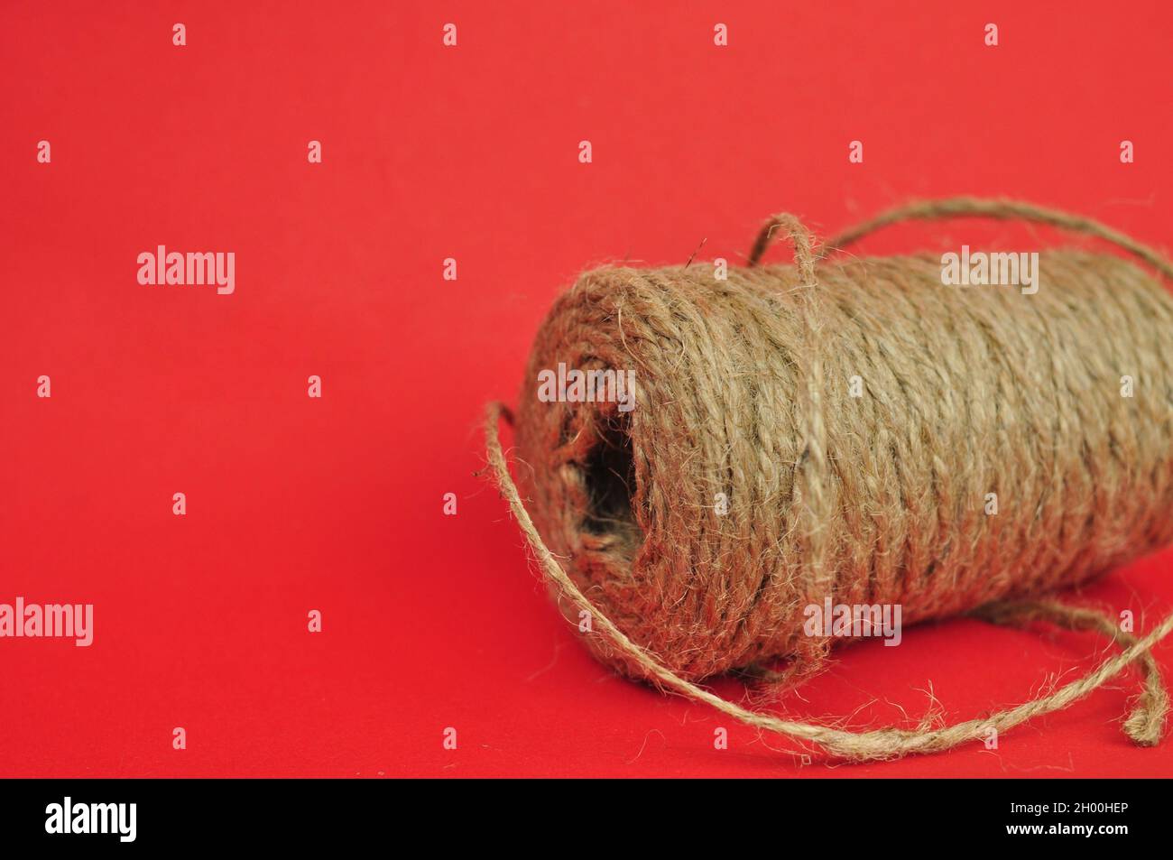 coil of rope for gift wrapping for Christmas on red background ...