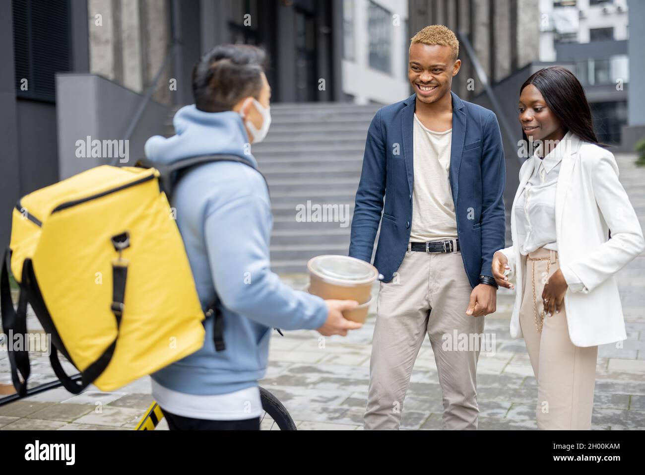 Courier giving food order to business people Stock Photo - Alamy