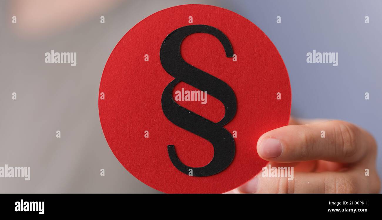 A red paragraph law sign in a hand Stock Photo - Alamy