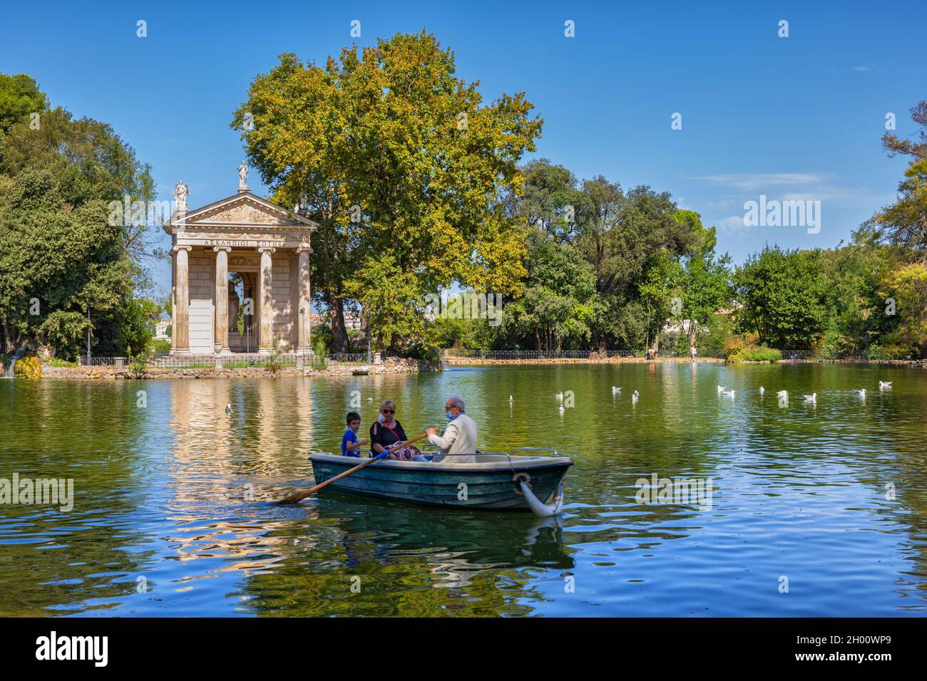 Italy, Rome, child with grandparents in rowing boat on the lake in ...