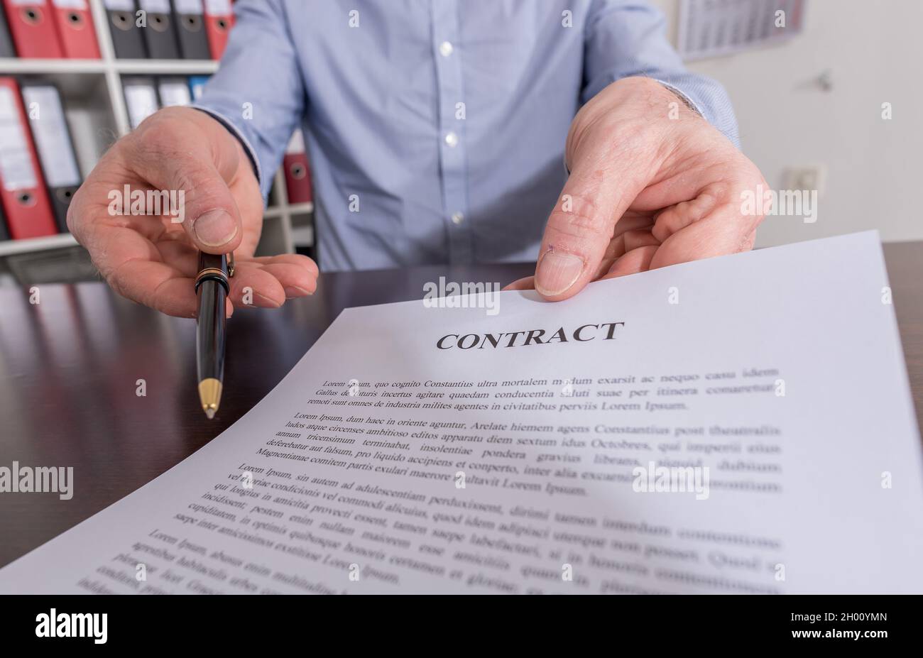 Businessman offering a pen for signing a contract Stock Photo - Alamy