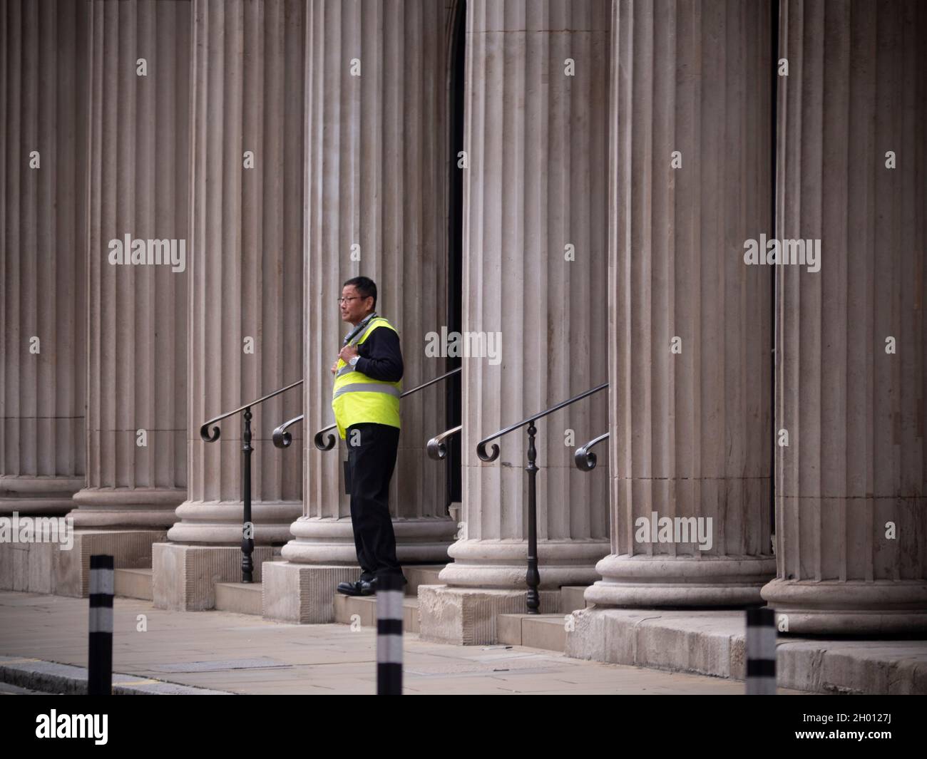Lone security guard stands outside the entrance of the Bank of England ...