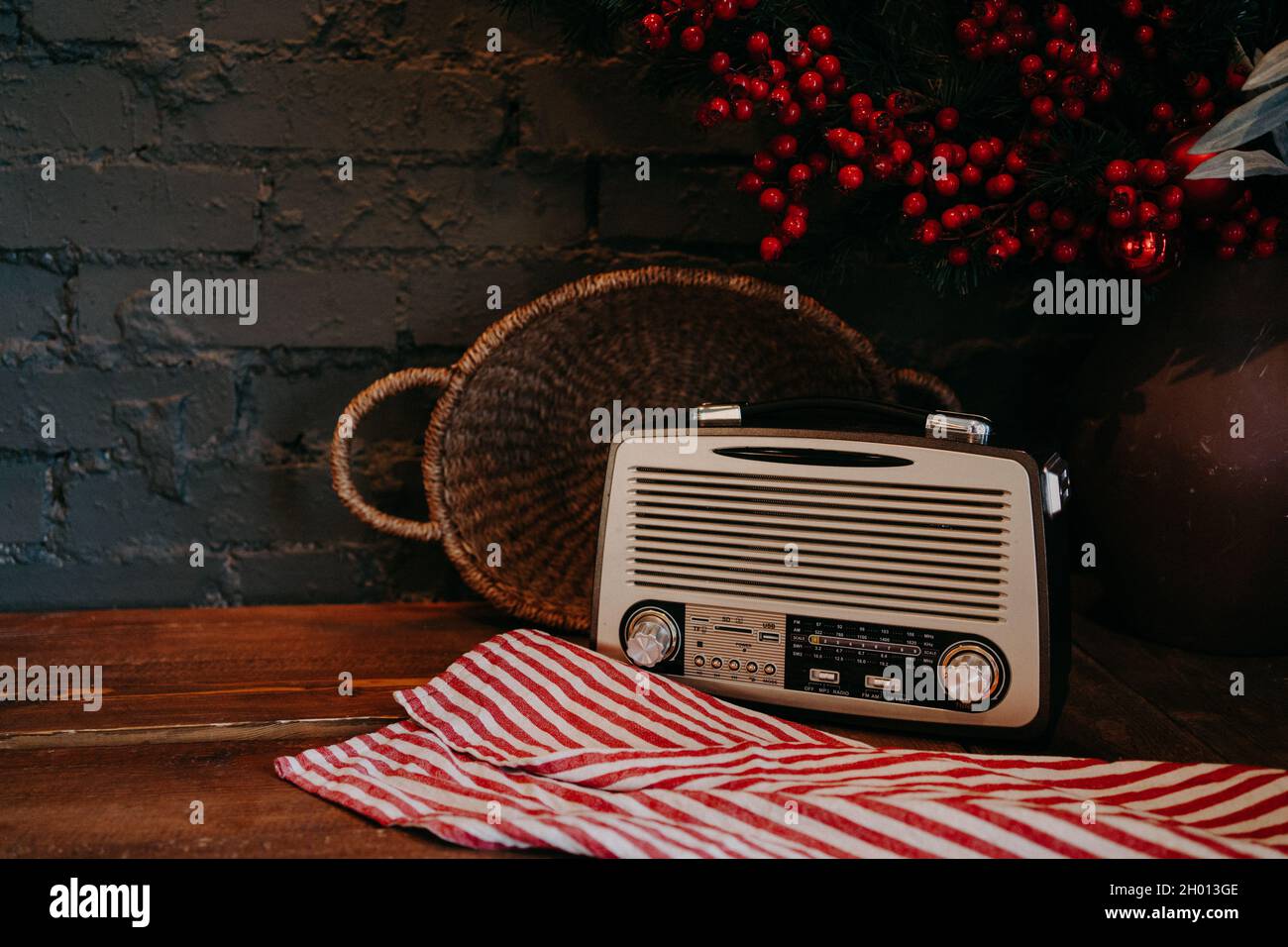 Retro radio on wooden table with wicker basket and floral decor ...