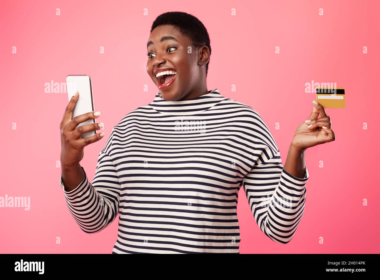 Mobile Shopping. Excited Plus-Size African Woman Using Phone And Credit ...