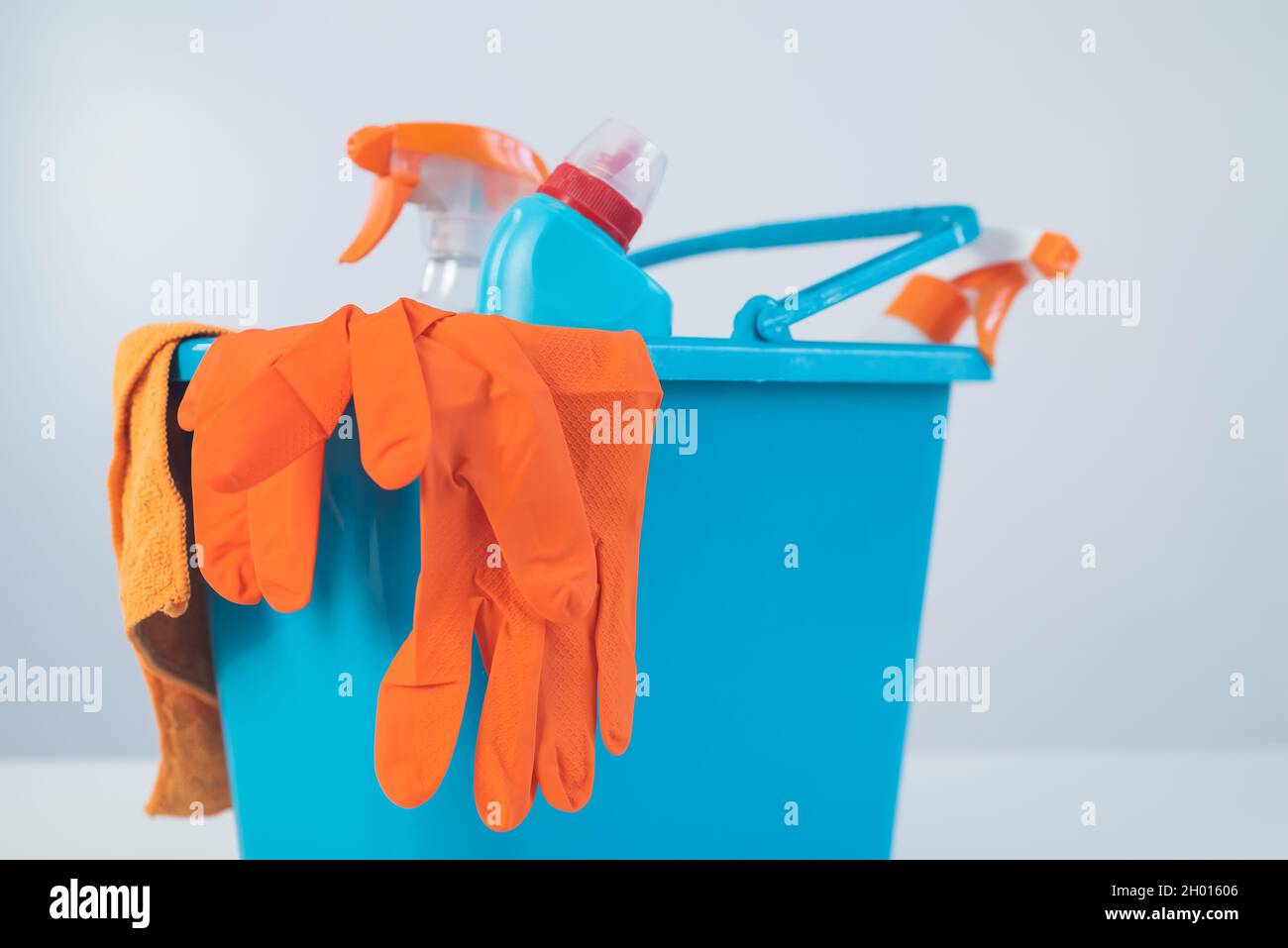Blue bucket with cleaning products and rubber gloves for homework on a ...