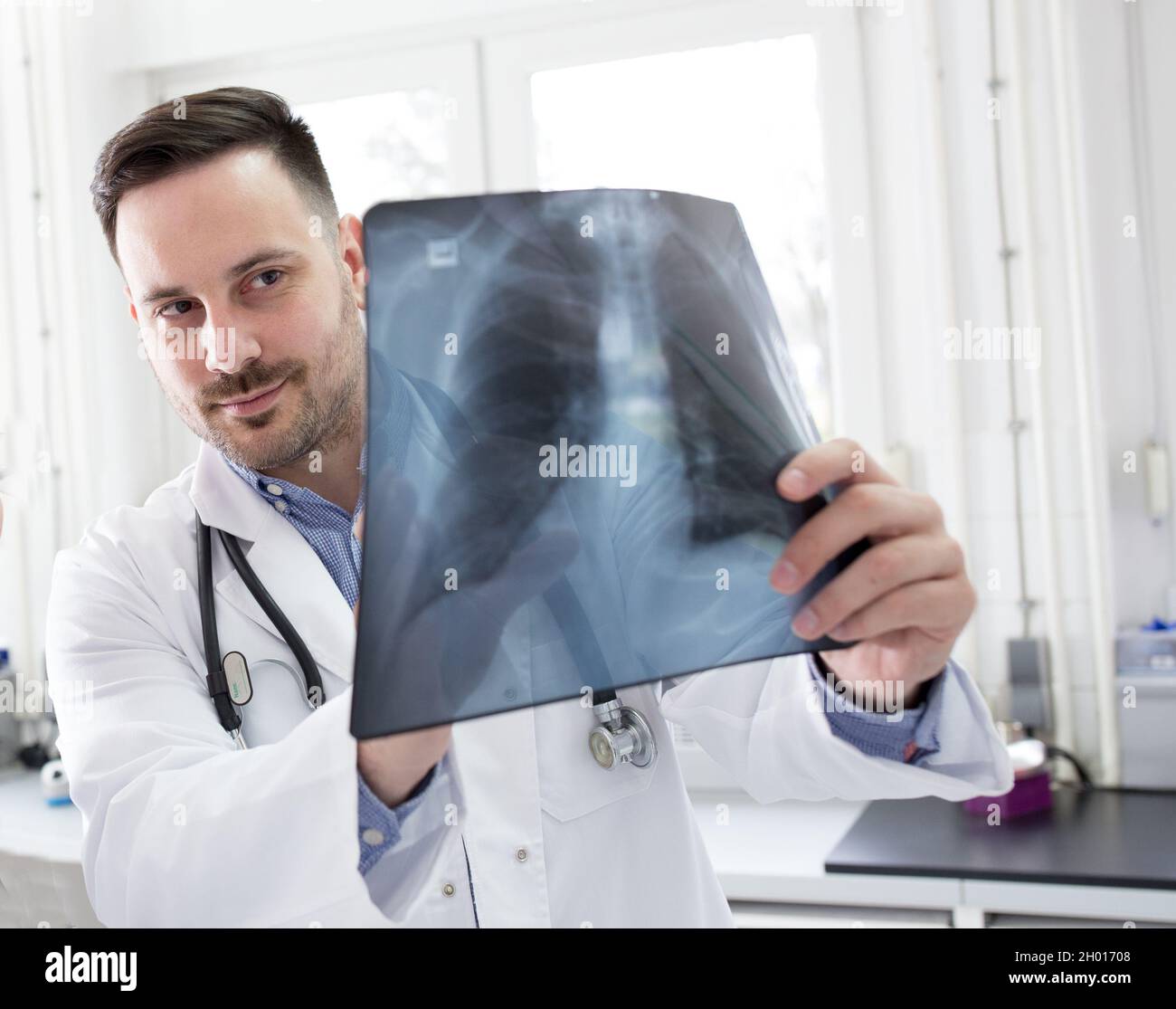 Male doctor holding x-ray of lungs and checking patient health ...