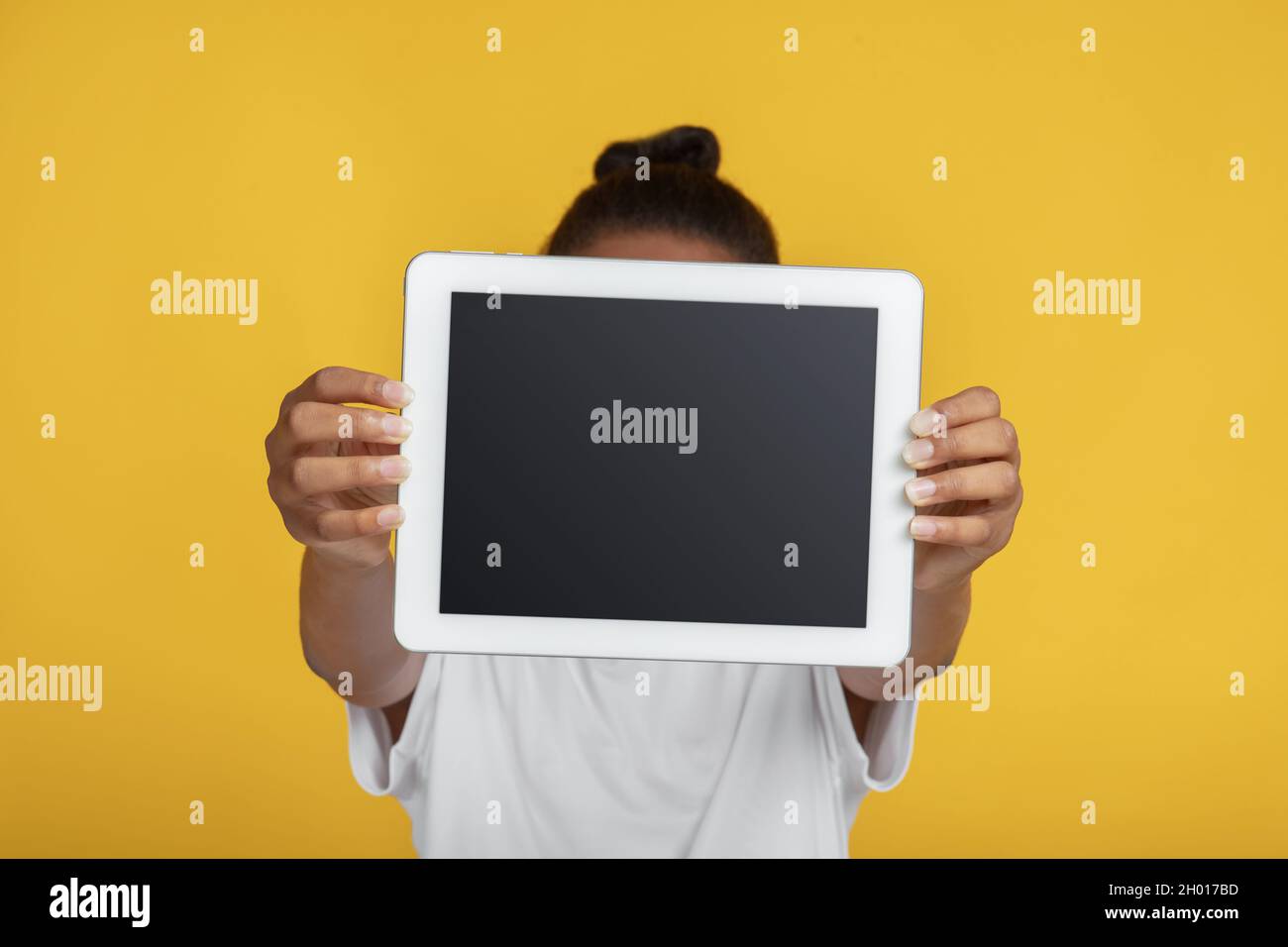 Unrecognizable teen afro american girl in white t-shirt show tablet ...