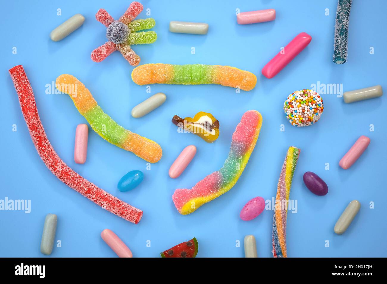 Sweets of different shapes and colors on a blue background. Jelly ...