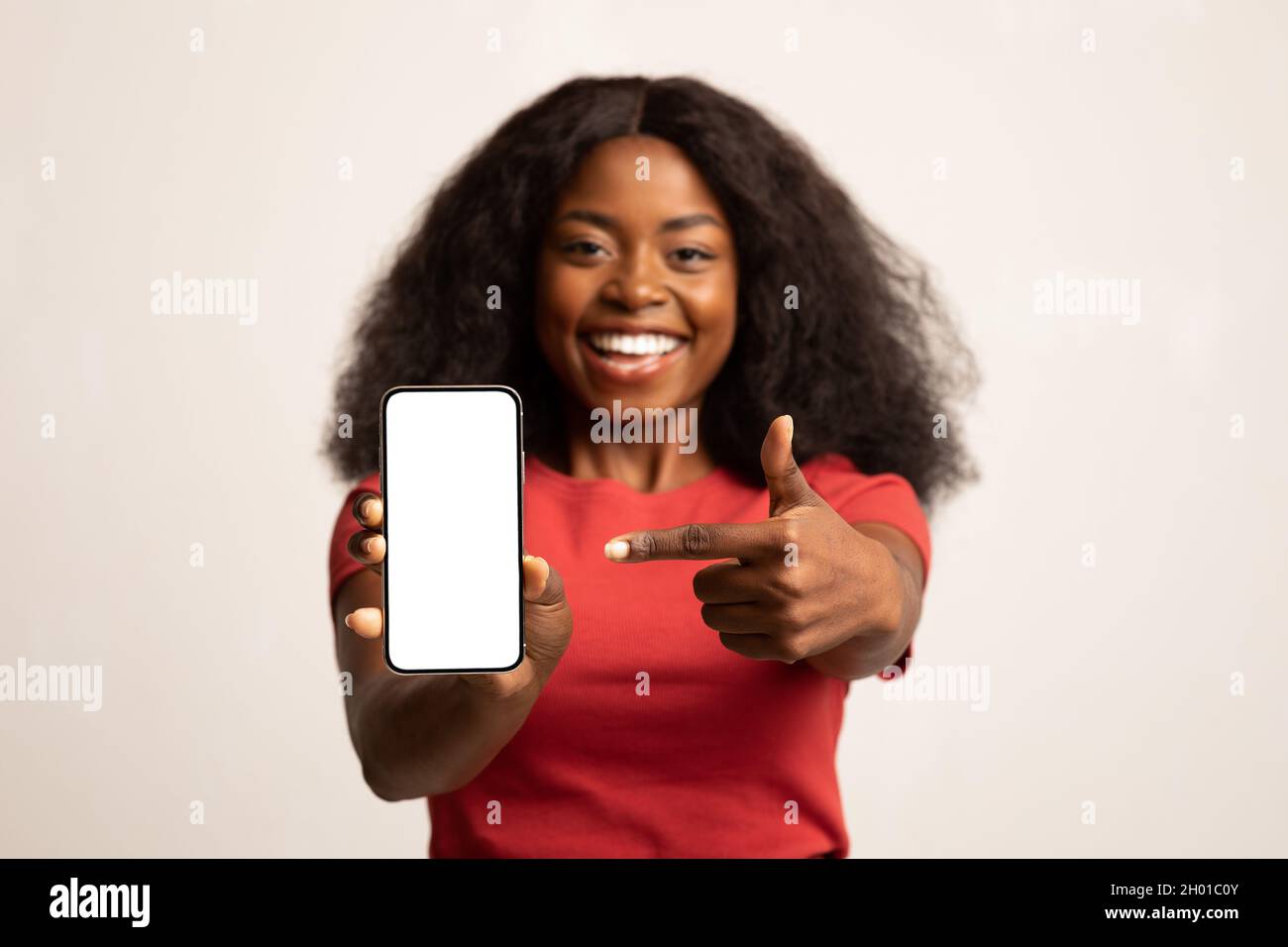 Mobile App. Cheerful Black Female Pointing At Smartphone With Blank ...